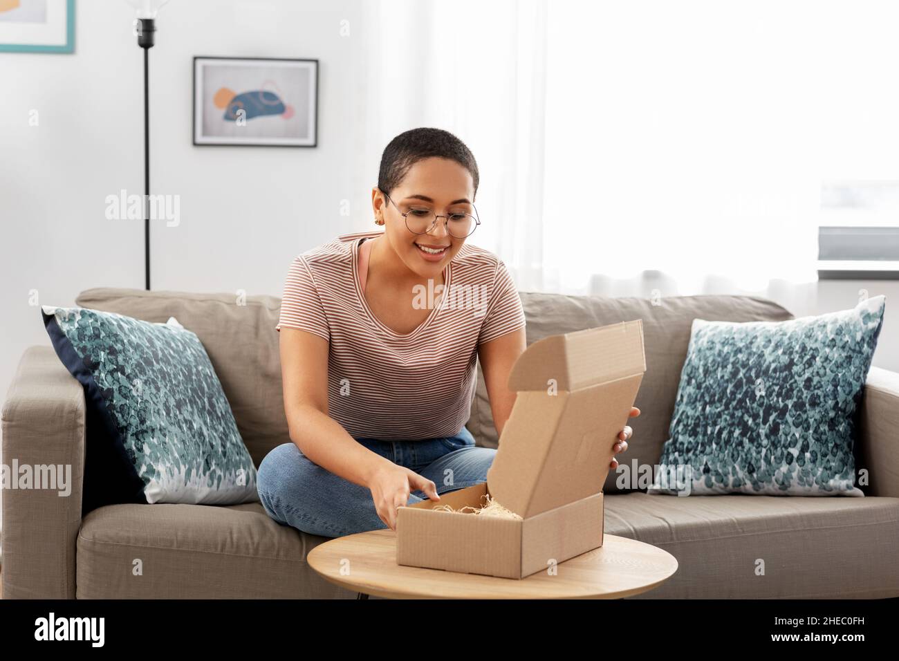 african american woman opening parcel box at home Stock Photo - Alamy