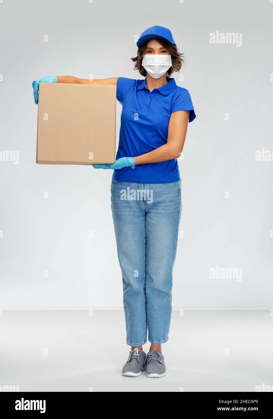 delivery woman in face mask holding parcel box Stock Photo - Alamy