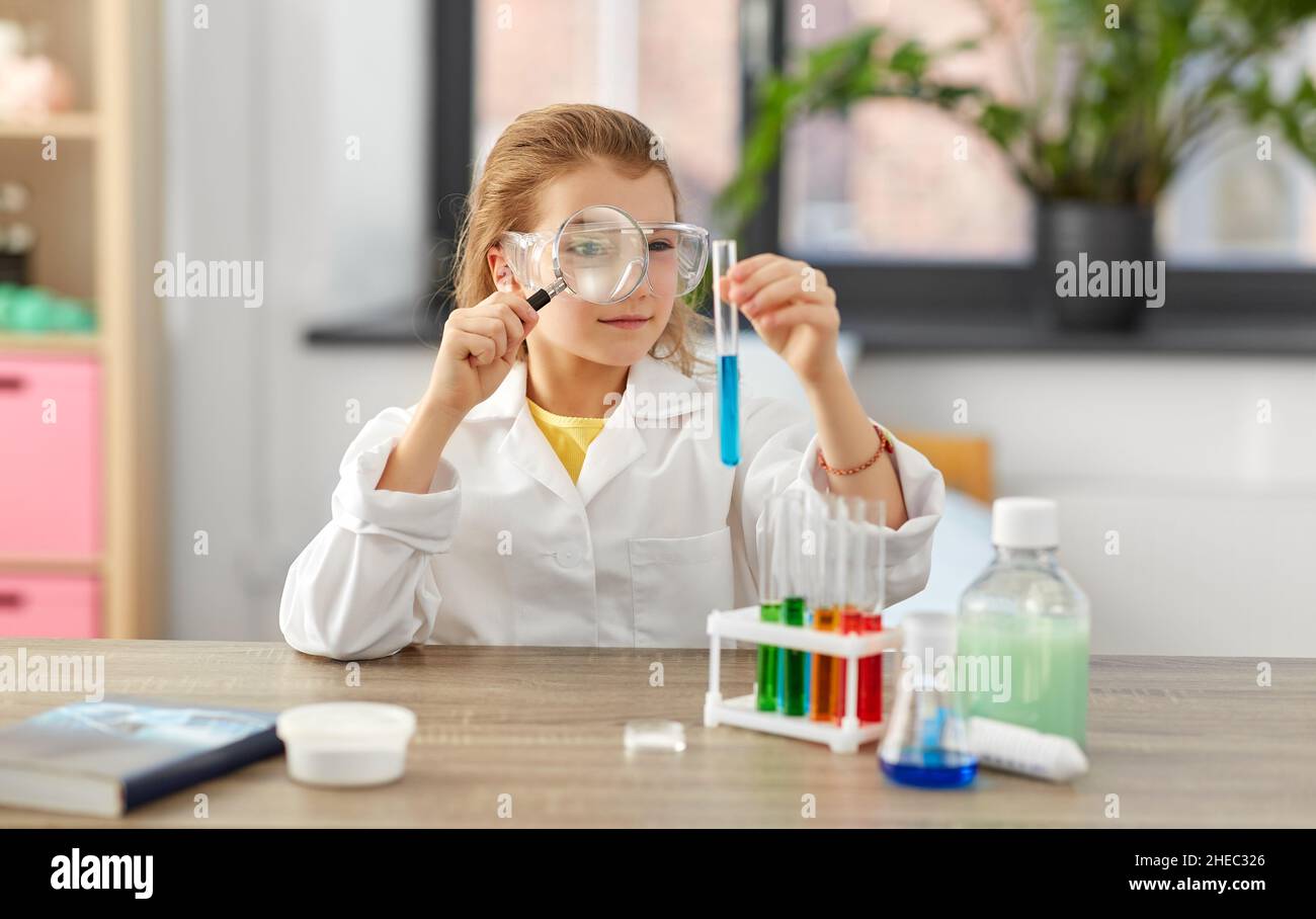 girl with magnifier and beaker at home laboratory Stock Photo - Alamy