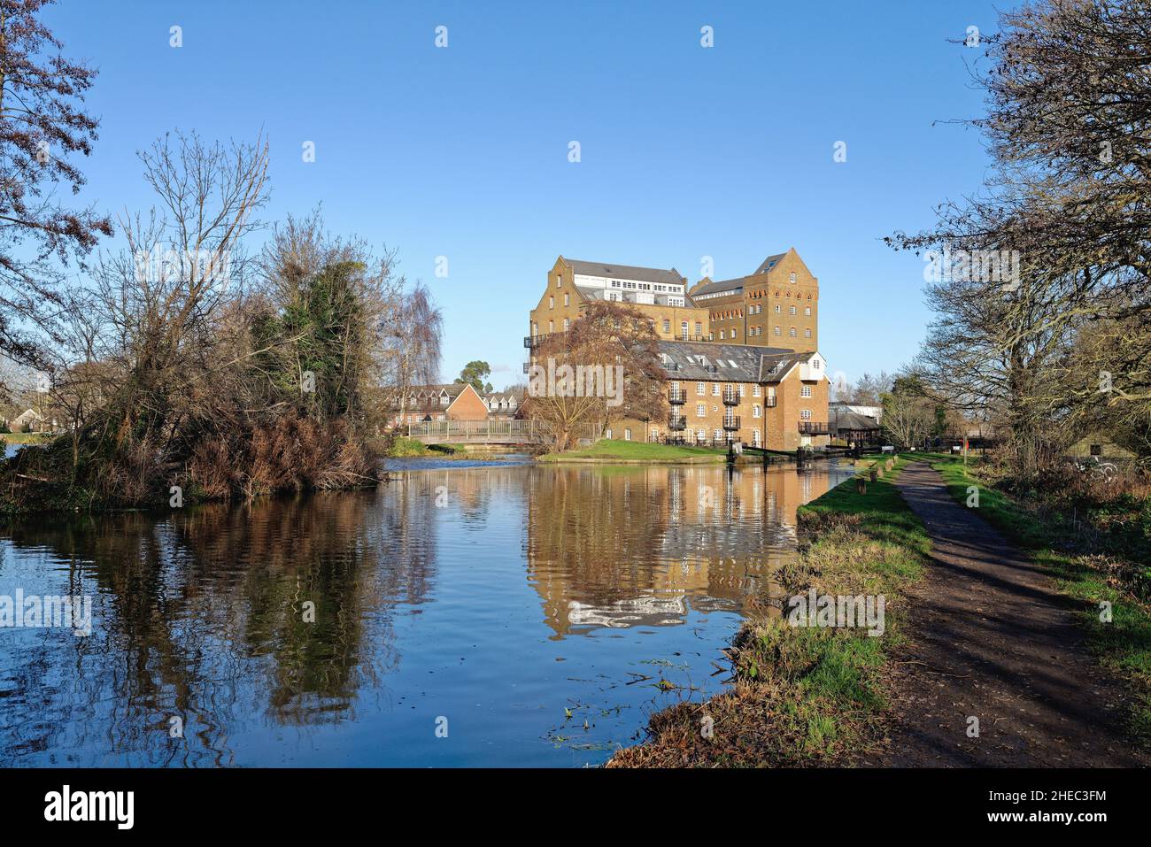 Coxes Lock Mill apartments on the River Wey Navigation canal on a sunny ...