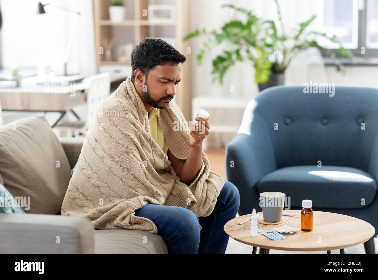 sad sick man in blanket with medicine at home Stock Photo - Alamy