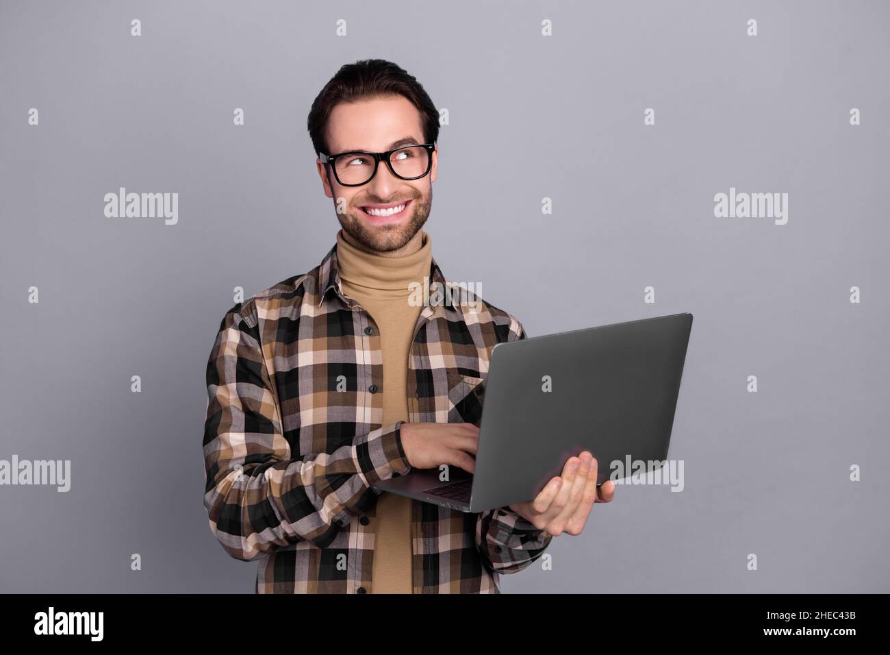 Portrait of attractive curious cheerful skilled guy expert using laptop ...