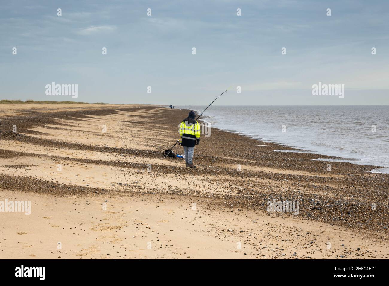 Man on beach sea fishing during a winters day on the east coast in ...