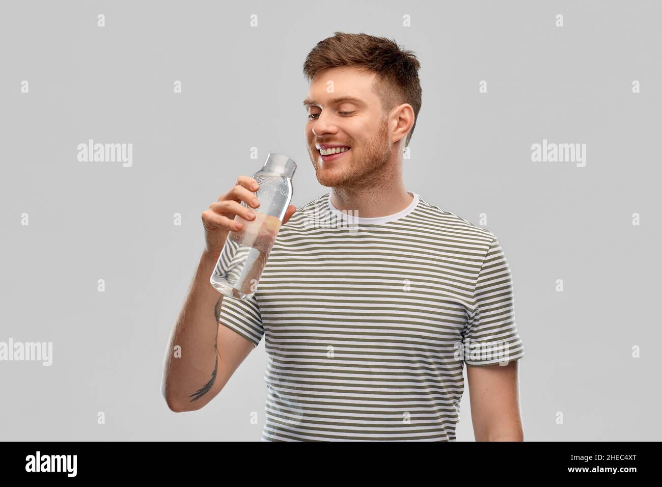 happy smiling man drinking water from glass bottle Stock Photo - Alamy