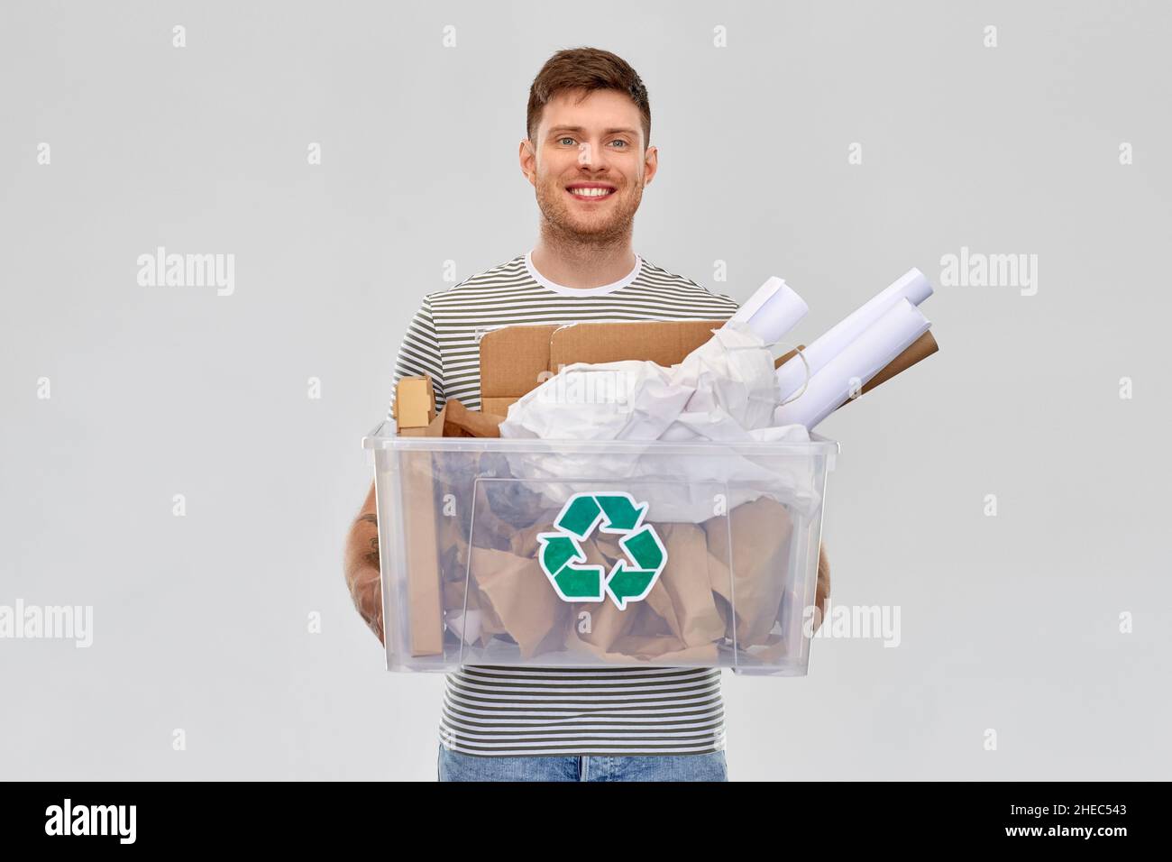 smiling young man sorting paper waste Stock Photo - Alamy