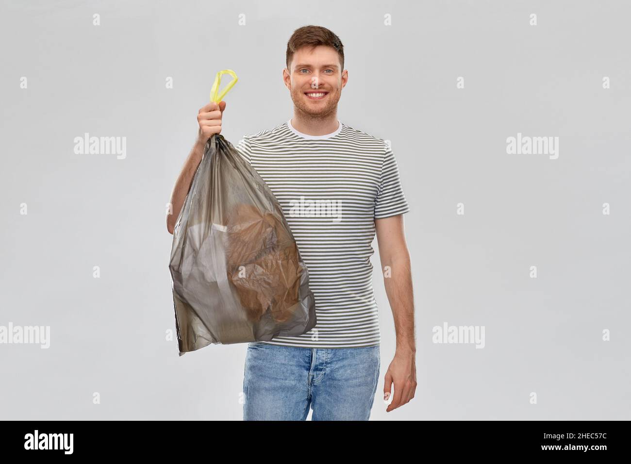 smiling man holding trash bag with paper waste Stock Photo - Alamy