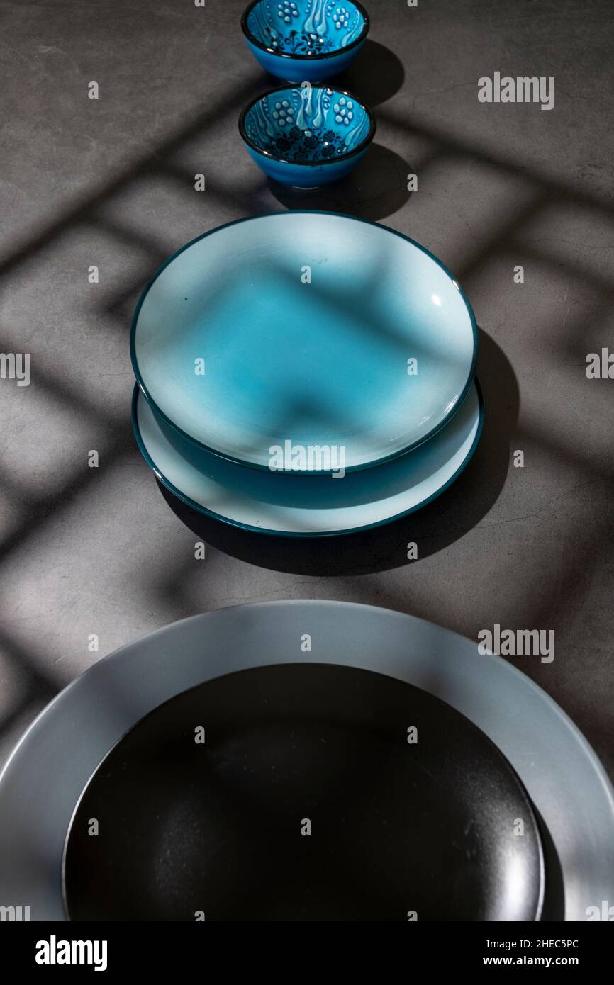 Tableware, different plates in grey blue colors on dark table with ...