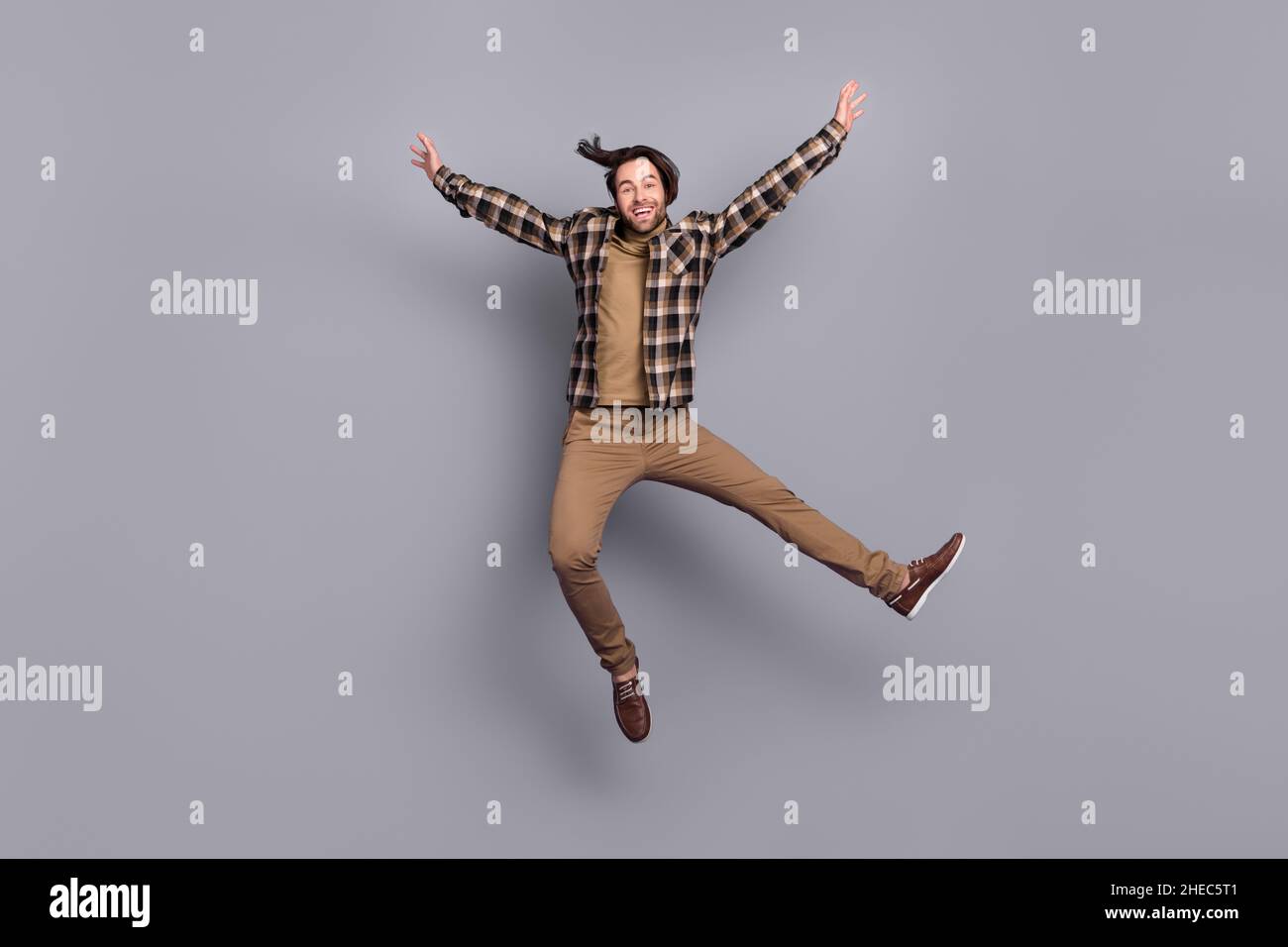 Photo of pretty funny man wear plaid shirt jumping like star falling ...