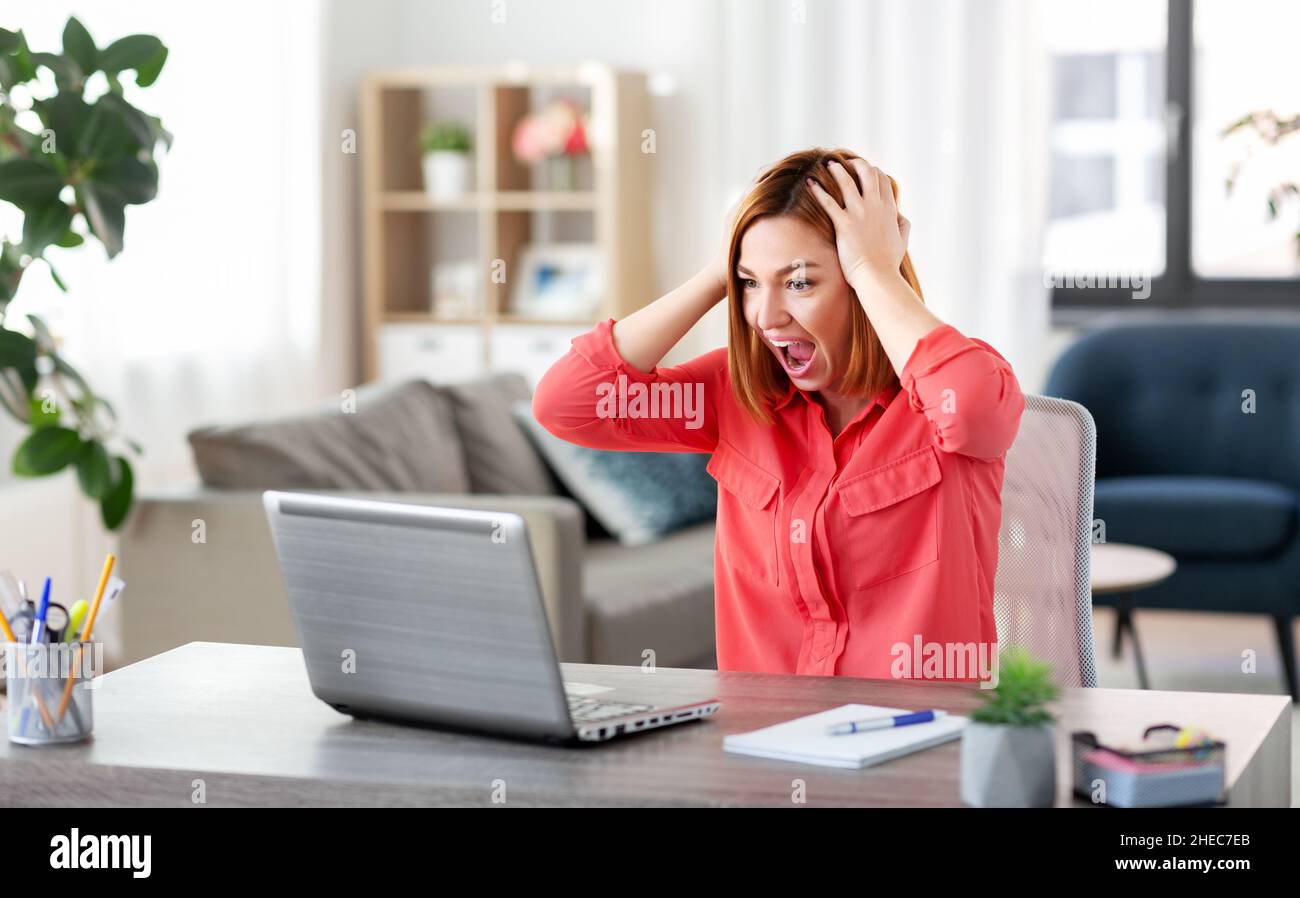 angry woman with laptop working at home office Stock Photo - Alamy