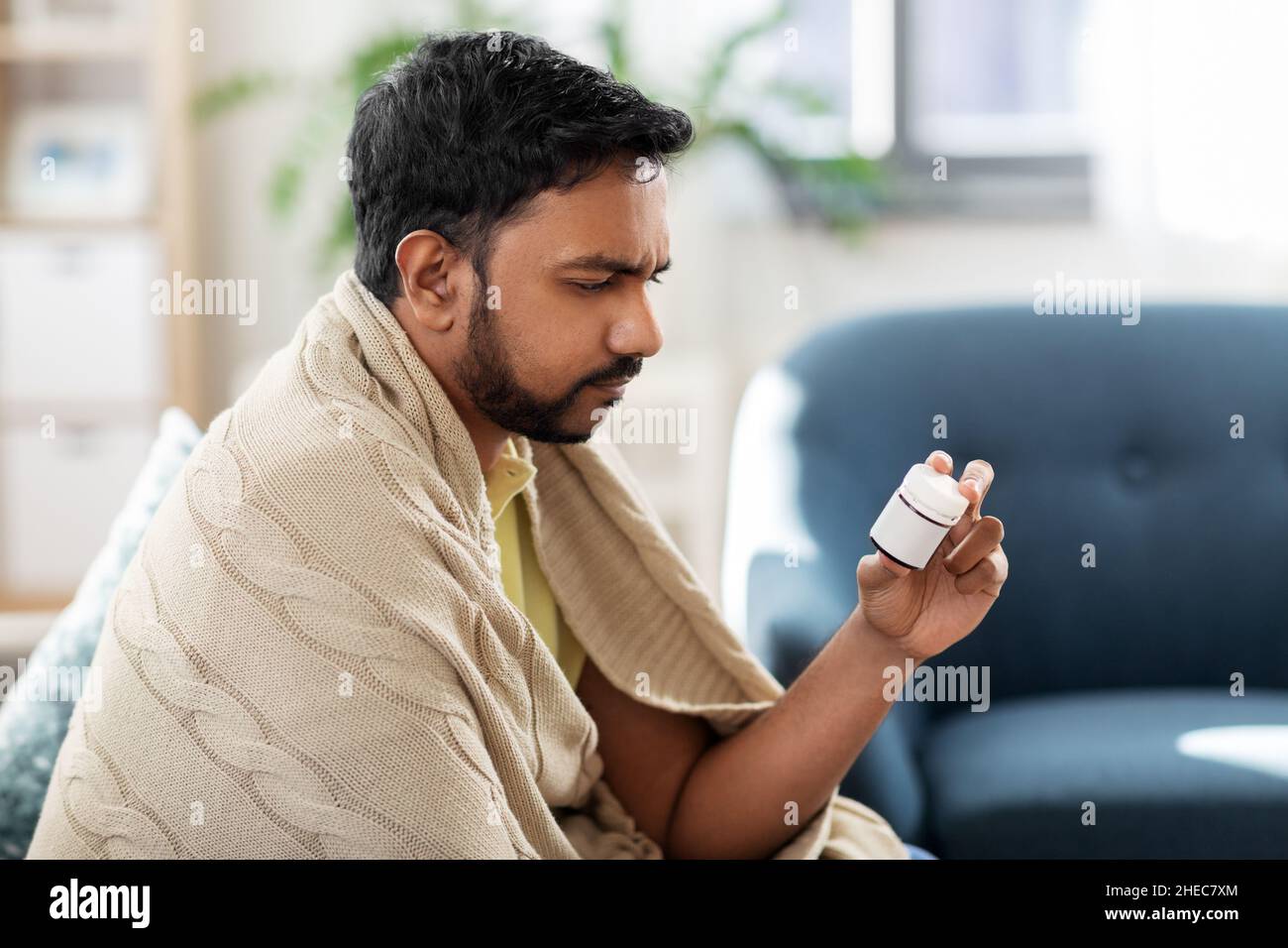 sad sick man in blanket with medicine at home Stock Photo - Alamy