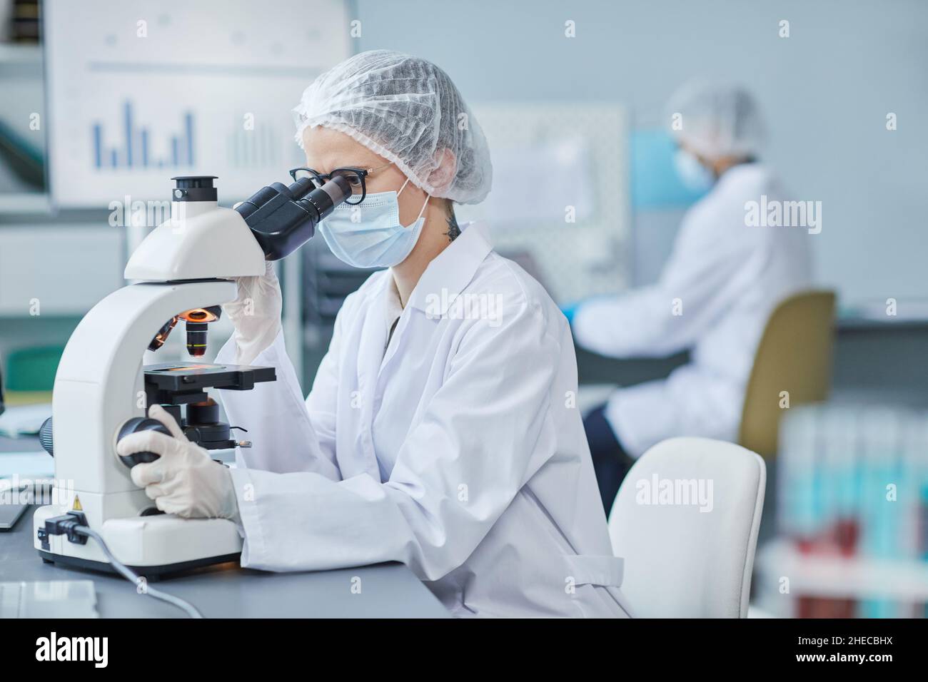 Doctor examining samples through microscope hi-res stock photography ...