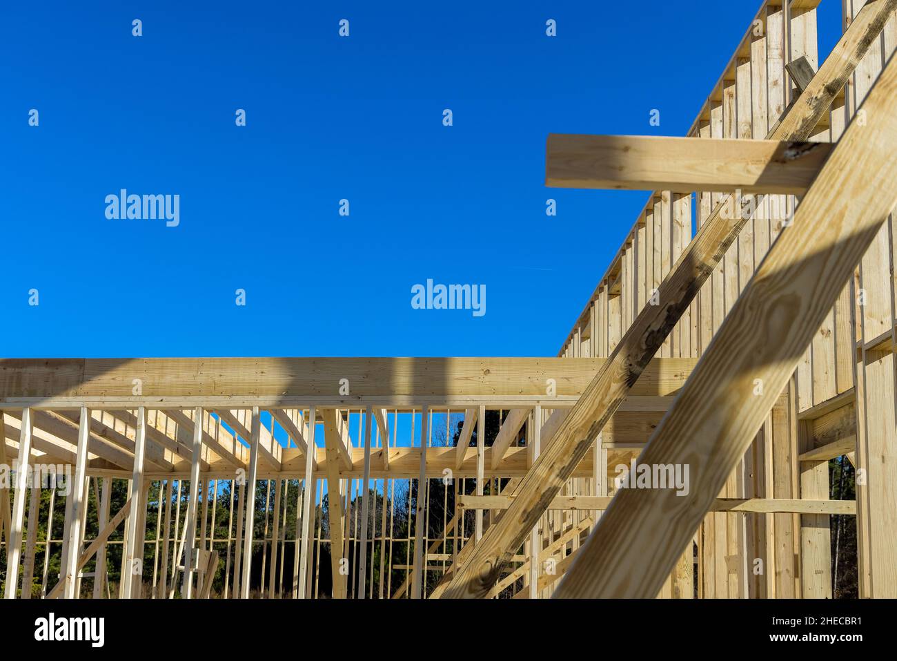 Exterior view of a new house under construction framing the beams stick ...