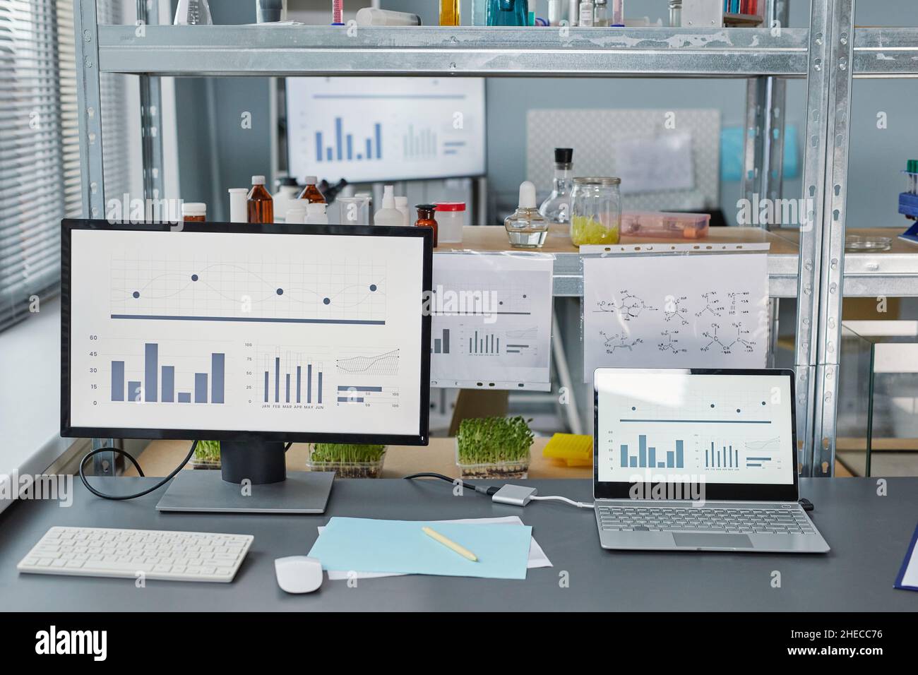 Image of computers with graphics on the screen and test tubes with ...