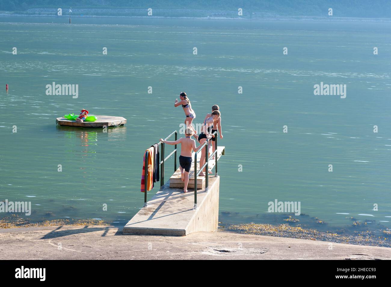 Kids having fun, jumping into cold fjord water, Eidfjord, Norway Stock ...