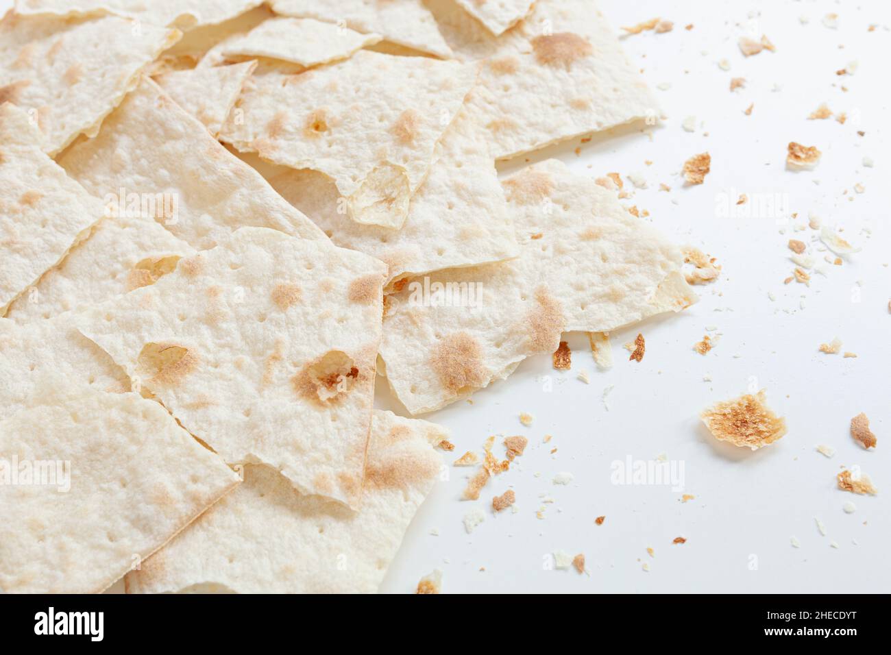 Dry flat bread broken in pieces and divided, with crumbs, on white ...