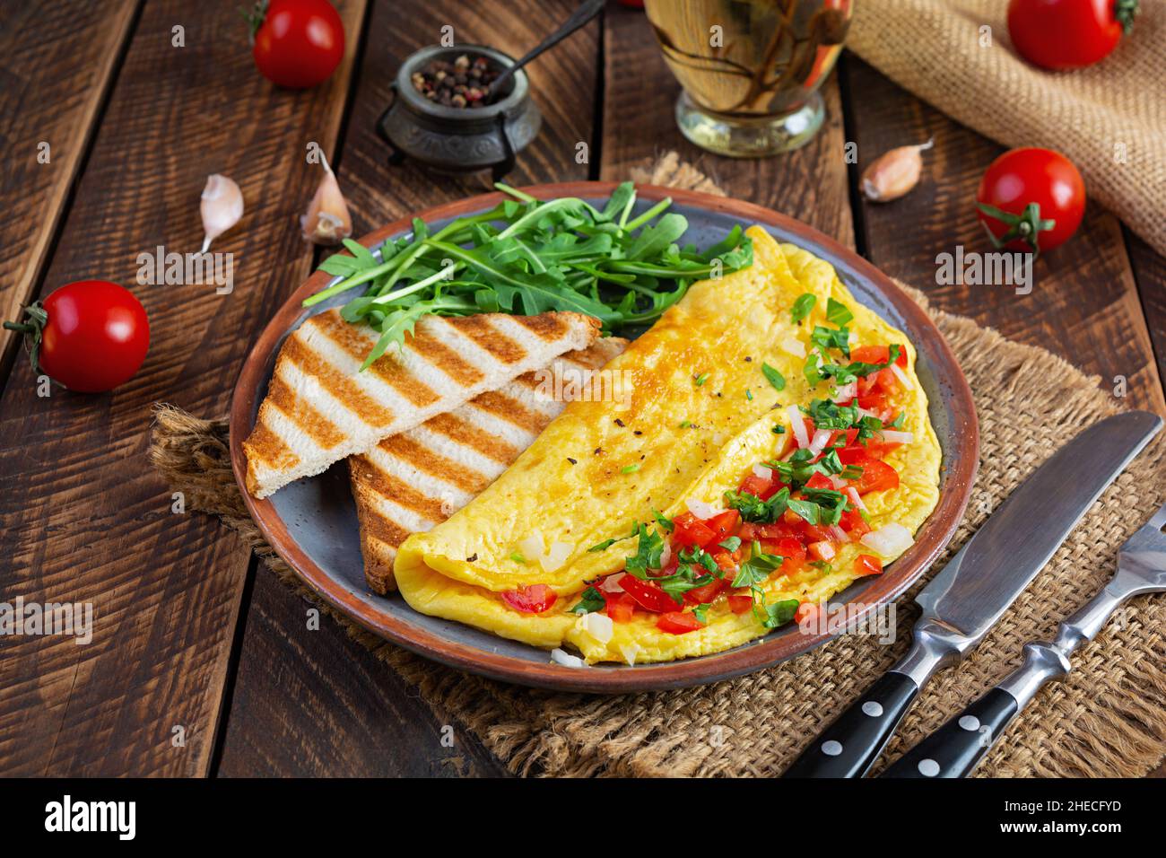 Fried omelette with tomatoes, onion and herbs. Delicious breakfast with eggs and toasts Stock ...
