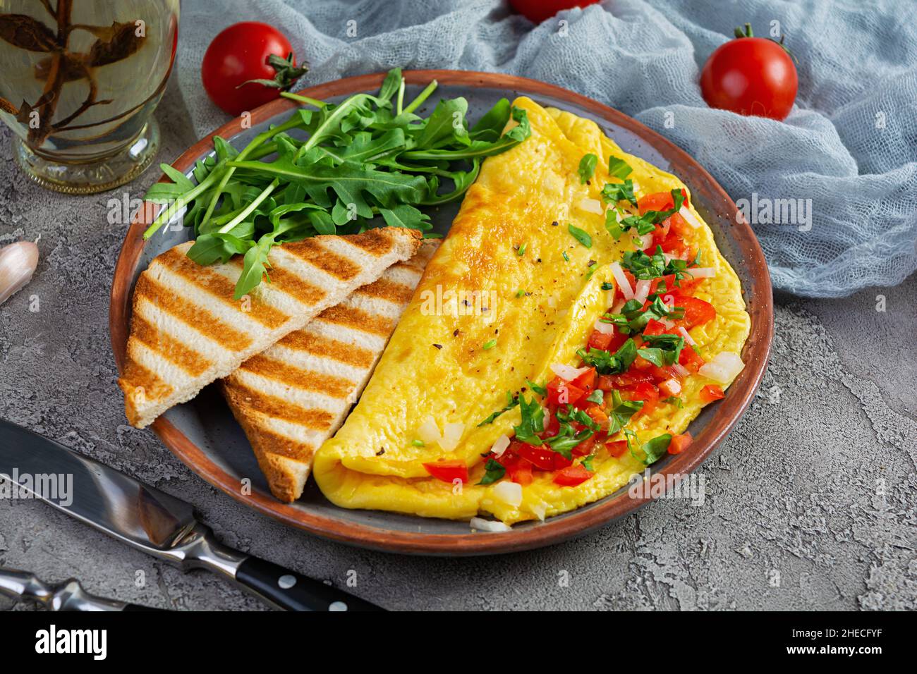 Fried omelette with tomatoes, onion and herbs. Delicious breakfast with ...
