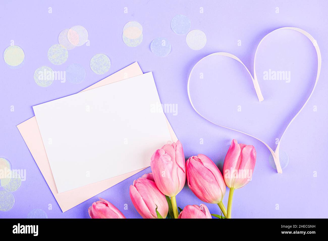 View from above tulips and heart with copy space on violet background ...