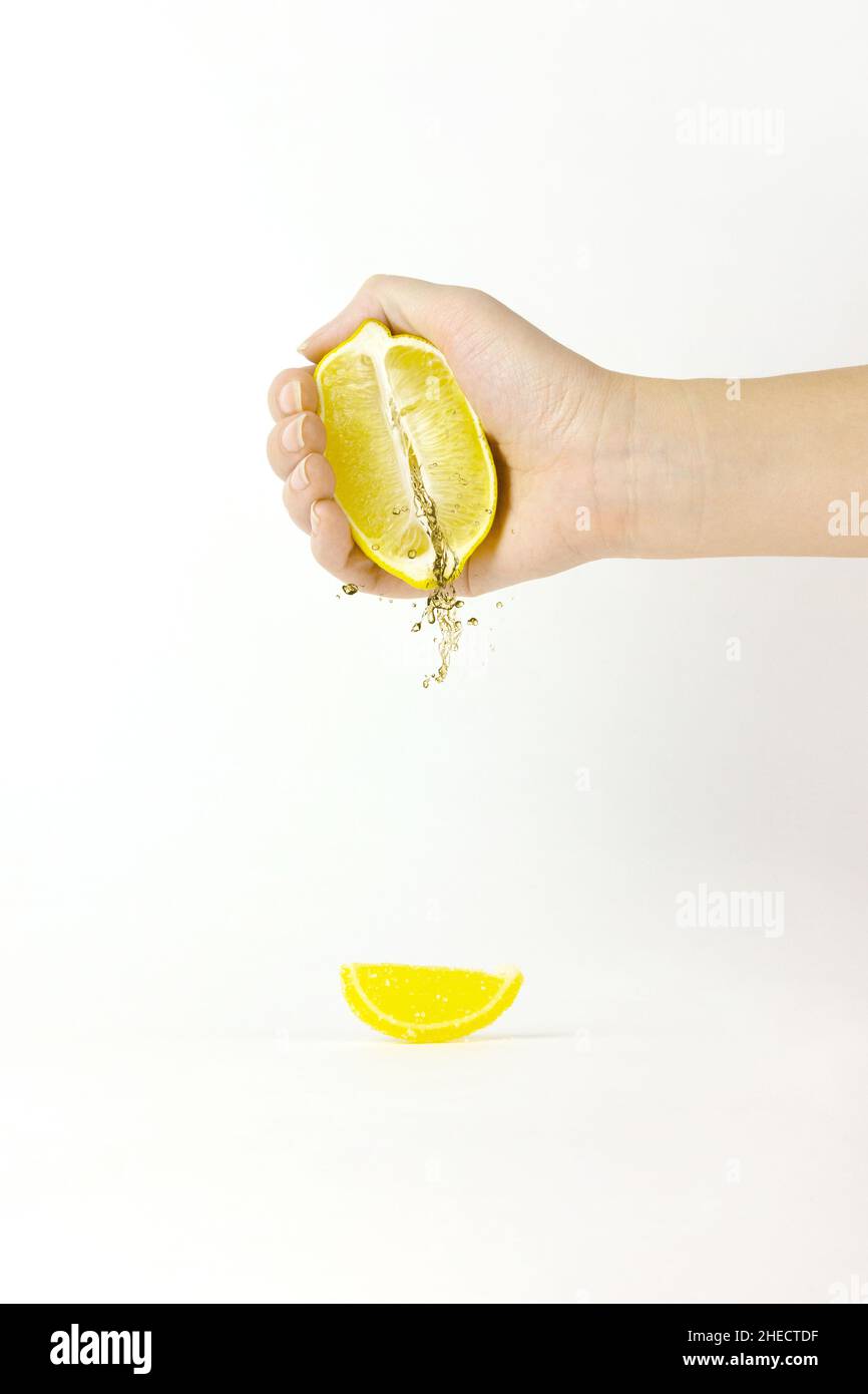 Female hand squeezing half of lemon in dessert marmalade in the form of ...