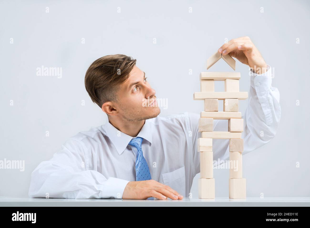 Businessman making tower Stock Photo - Alamy