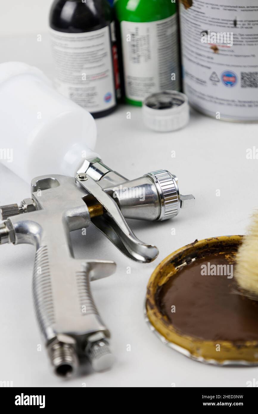 Instructions and a paint spray gun at work at the workplace in the ...