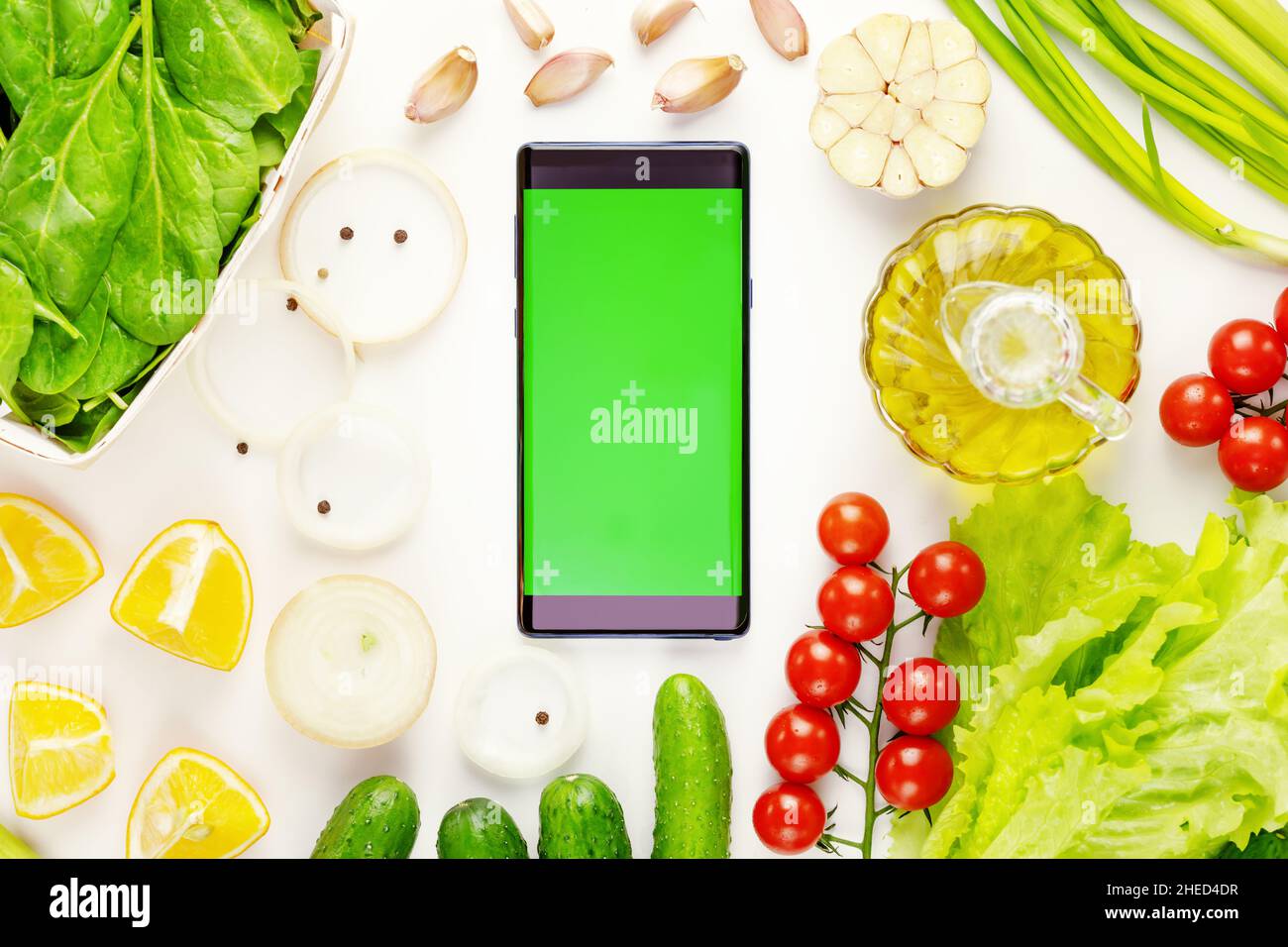 Organic vegetables and smartphone with green screen on a white ...