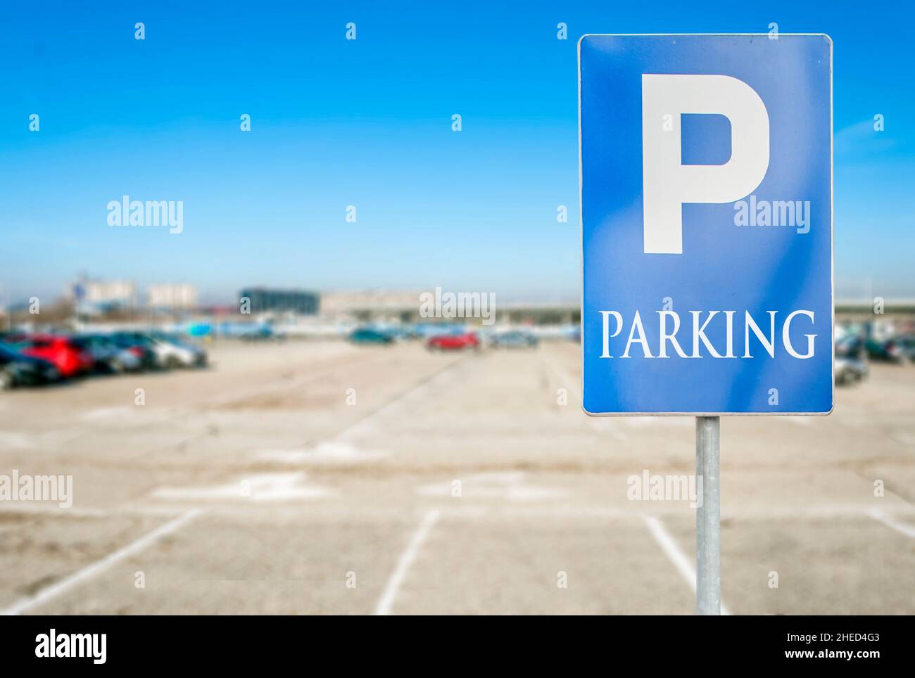 Blue parking sign with blurred cars at the background Stock Photo - Alamy