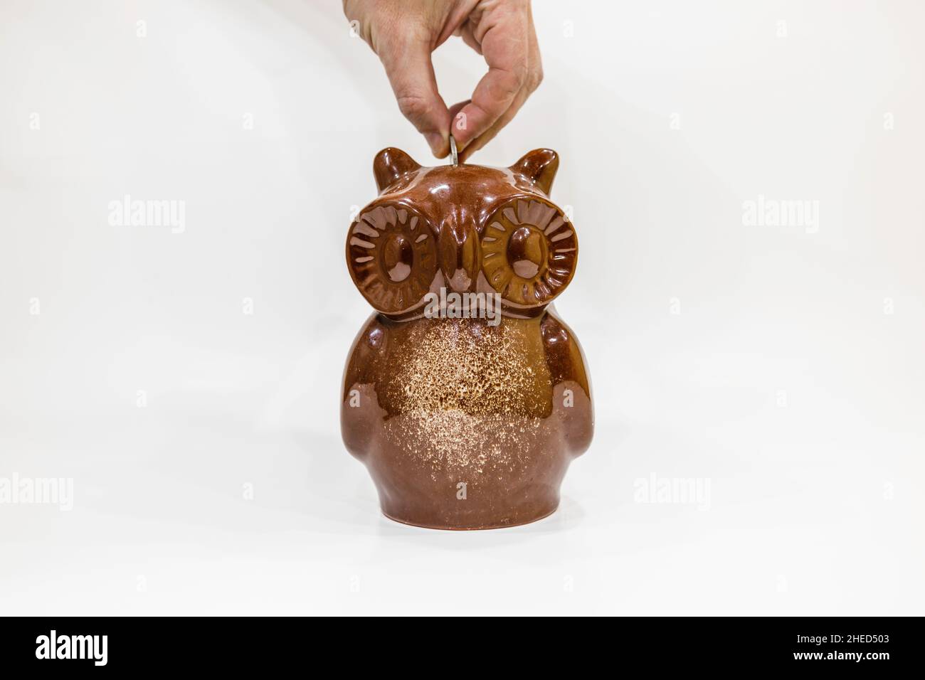 human hand putting coin In money box on white background Stock Photo ...