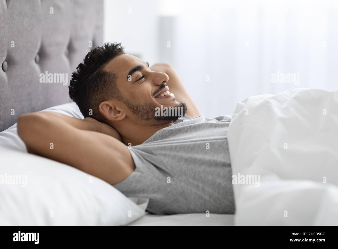 Morning Relax Smiling Pleased Arab Man Lying In Bed After Waking Up