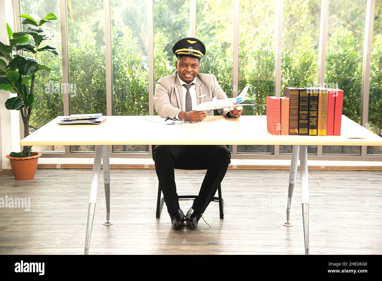 An African male flight attendant poses at his desk in the workplace ...