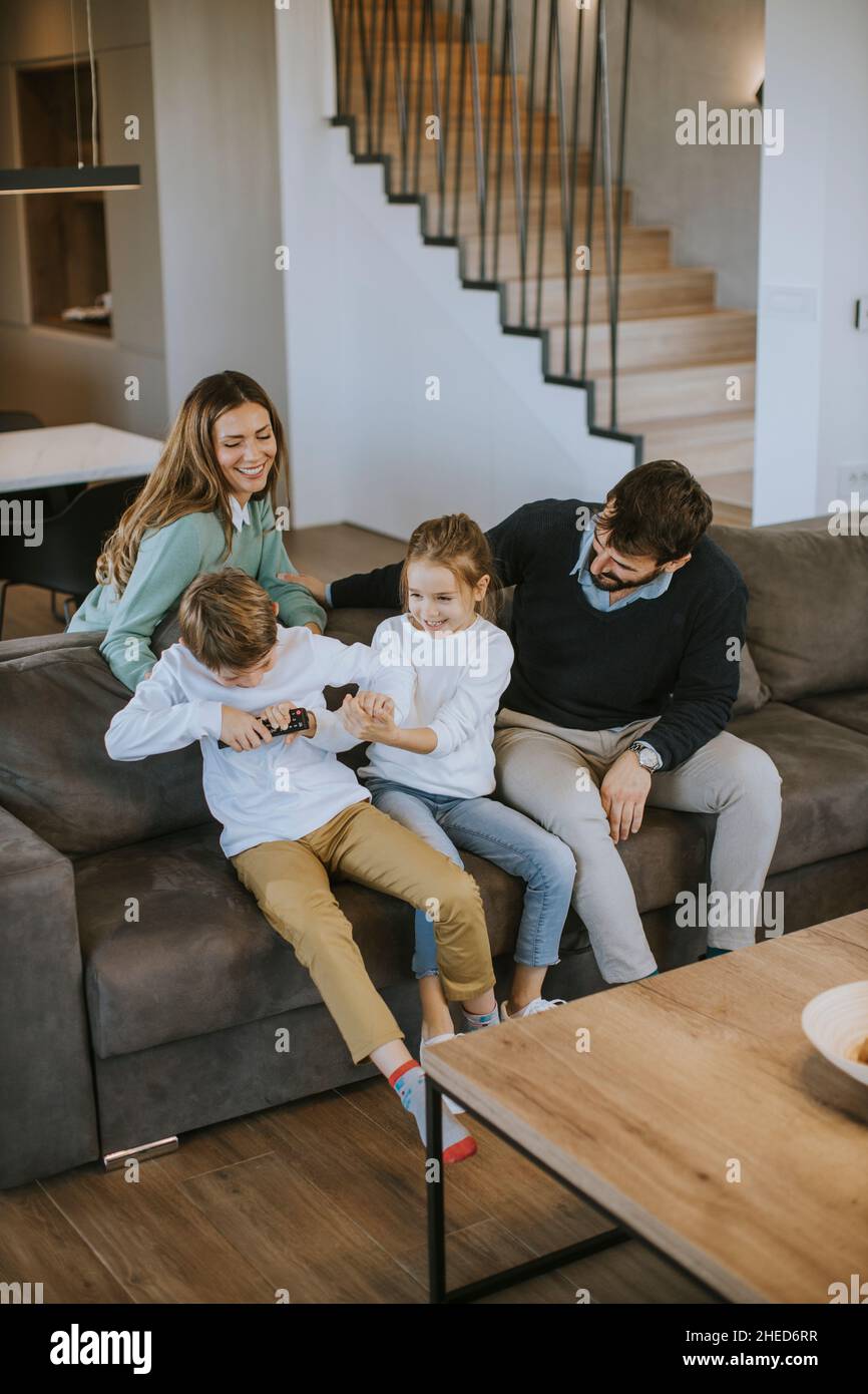 Cute siblings fighting over TV remote control at home Stock Photo - Alamy