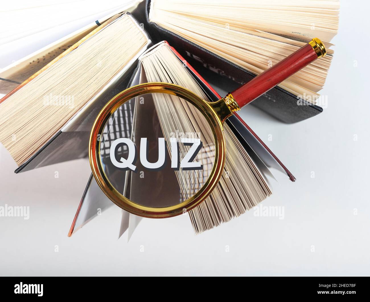 Word quiz through magnifying glass on books Stock Photo - Alamy