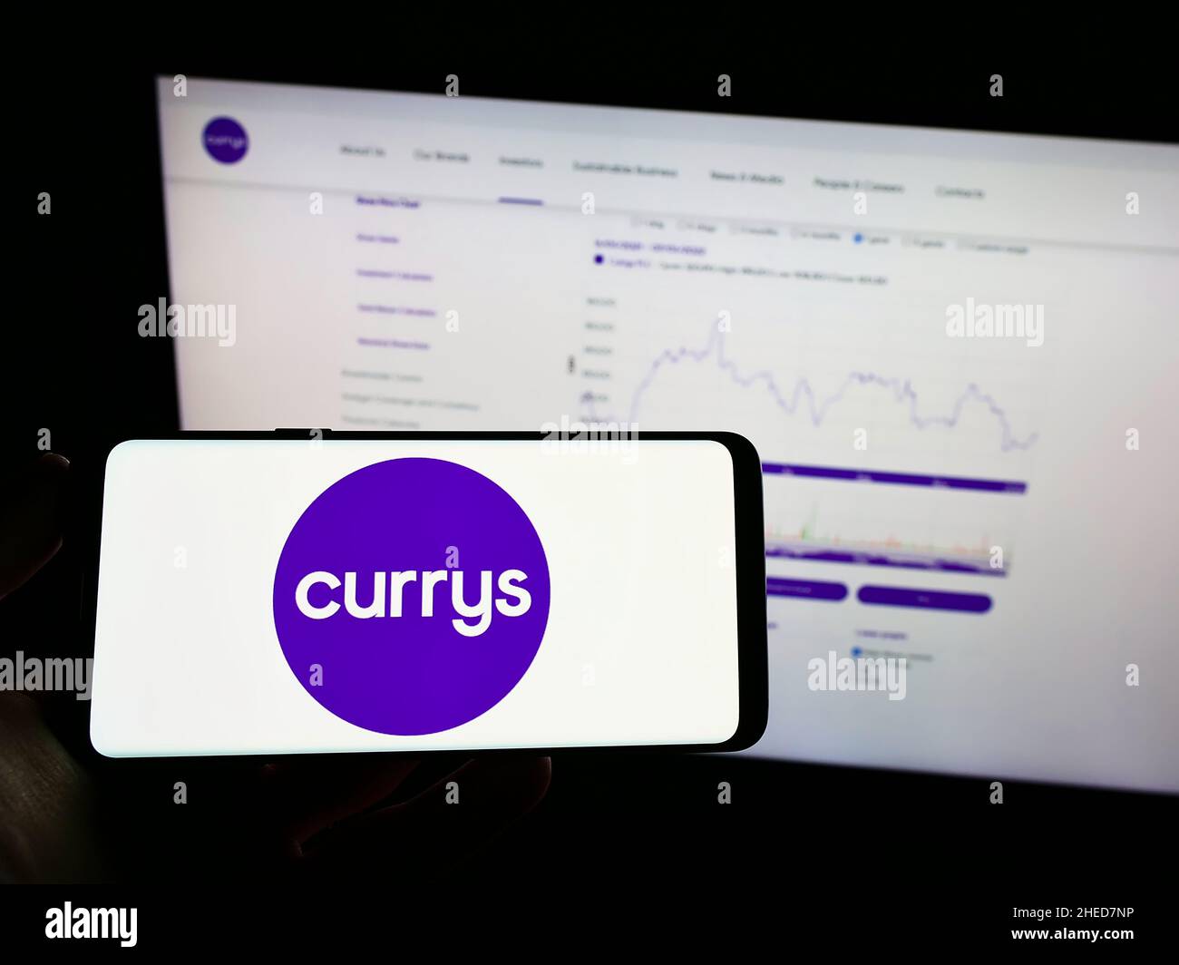 Person holding mobile phone with logo of British electronics retail ...