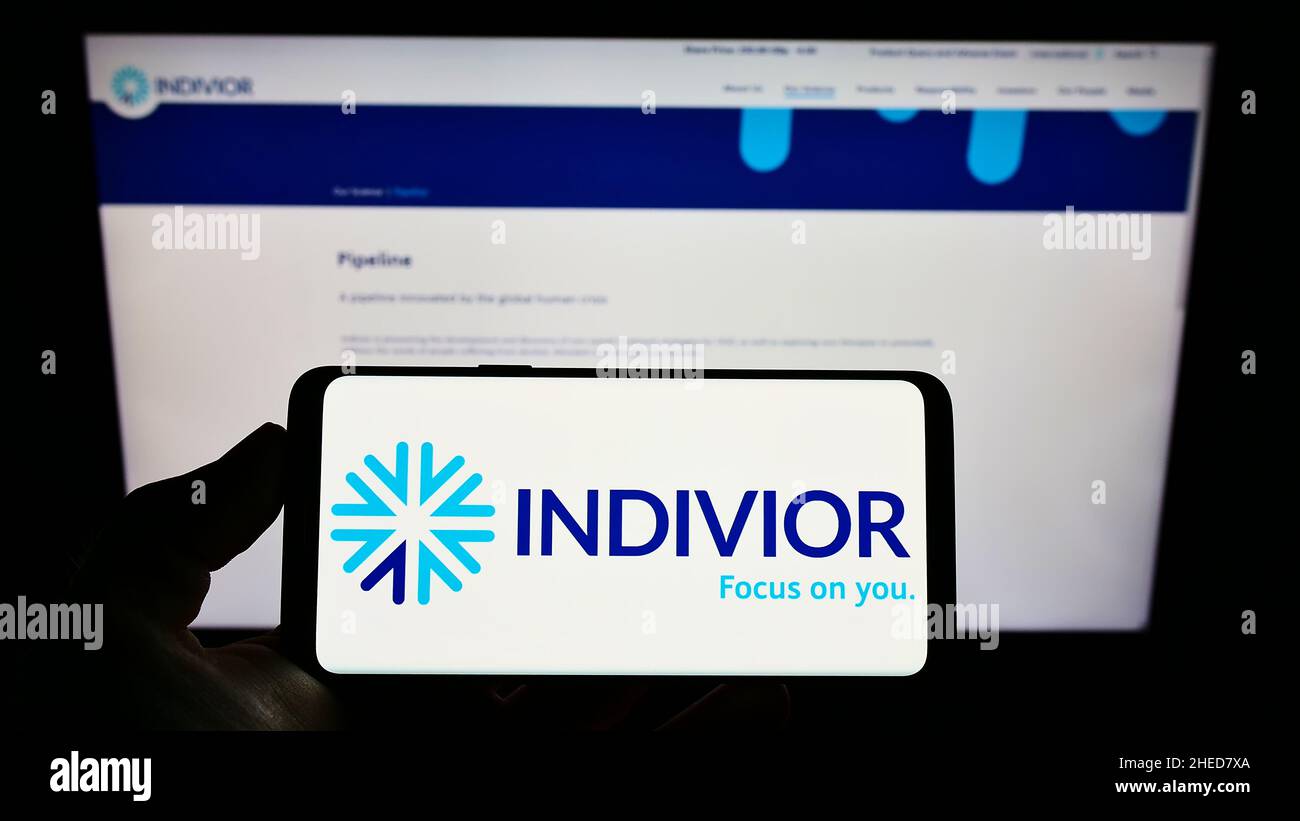 Person holding cellphone with logo of British pharmaceutical company ...