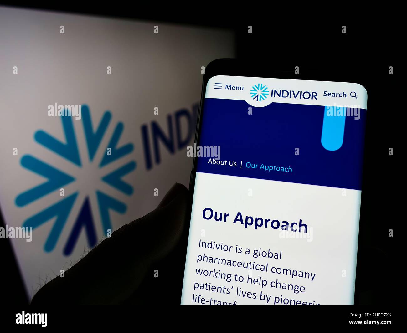 Person holding cellphone with website of British pharmaceutical company ...