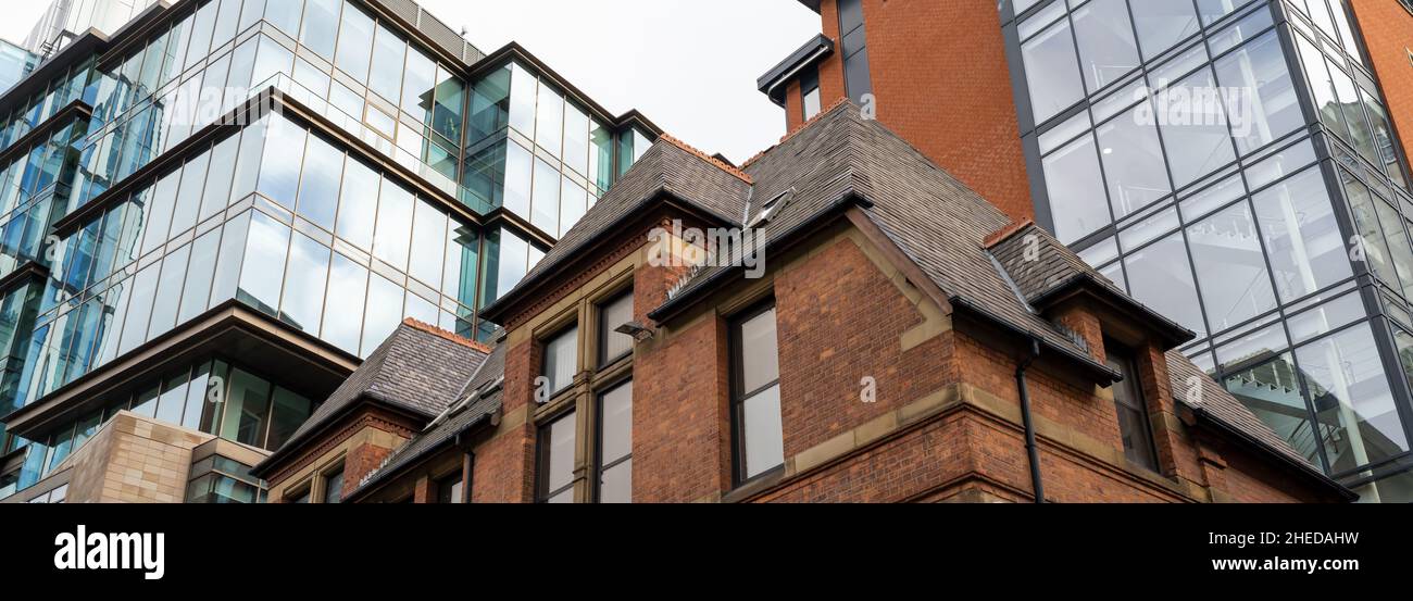 old brick building with modern glass office building behind Stock Photo ...