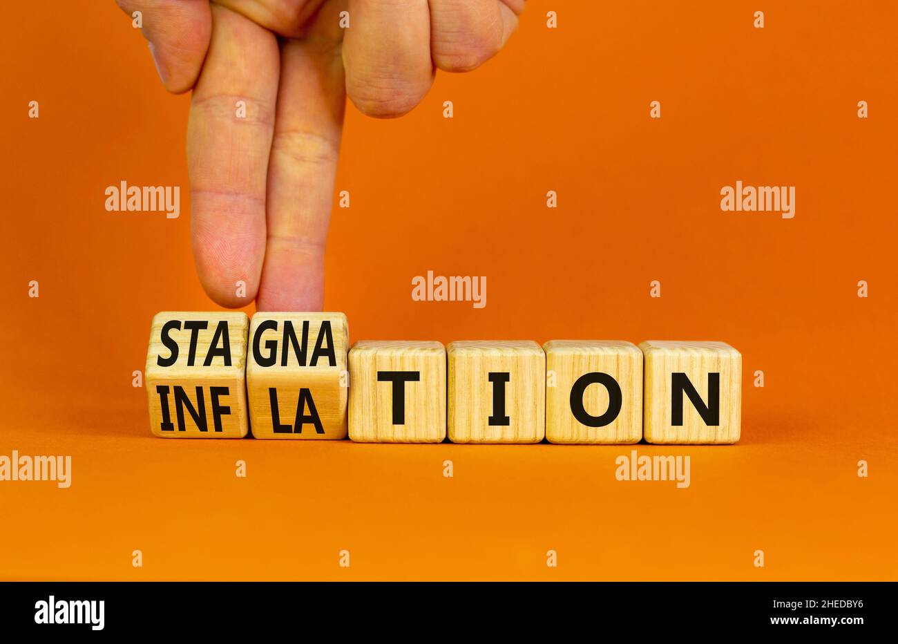 Inflation and stagnation symbol. Businessman turns cubes, changes the ...