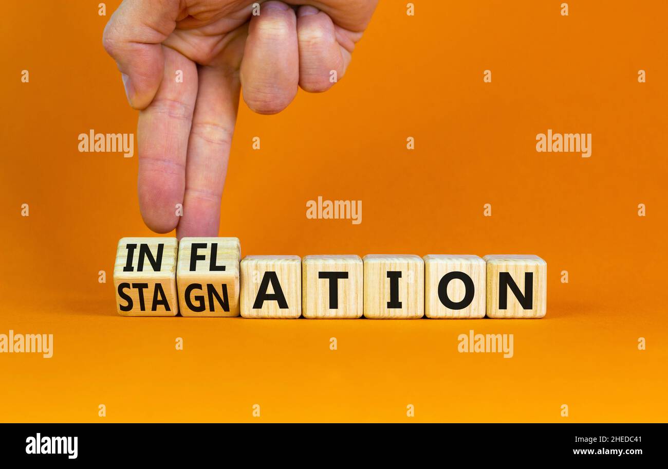 Inflation and stagnation symbol. Businessman turns cubes, changes the ...