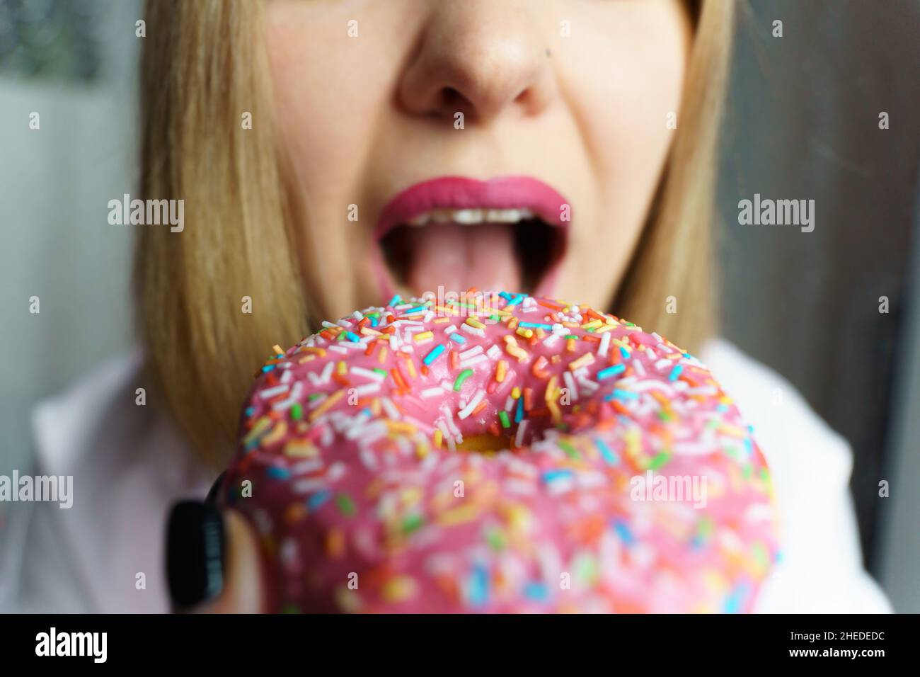 Portrait pretty girl eating donuts. Young caucasian girl eating donuts ...