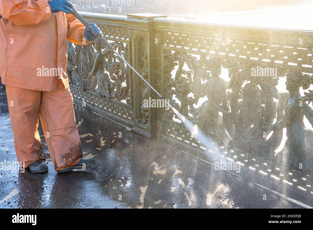 Worker cleaning driveway with gasoline high pressure washer splashing ...