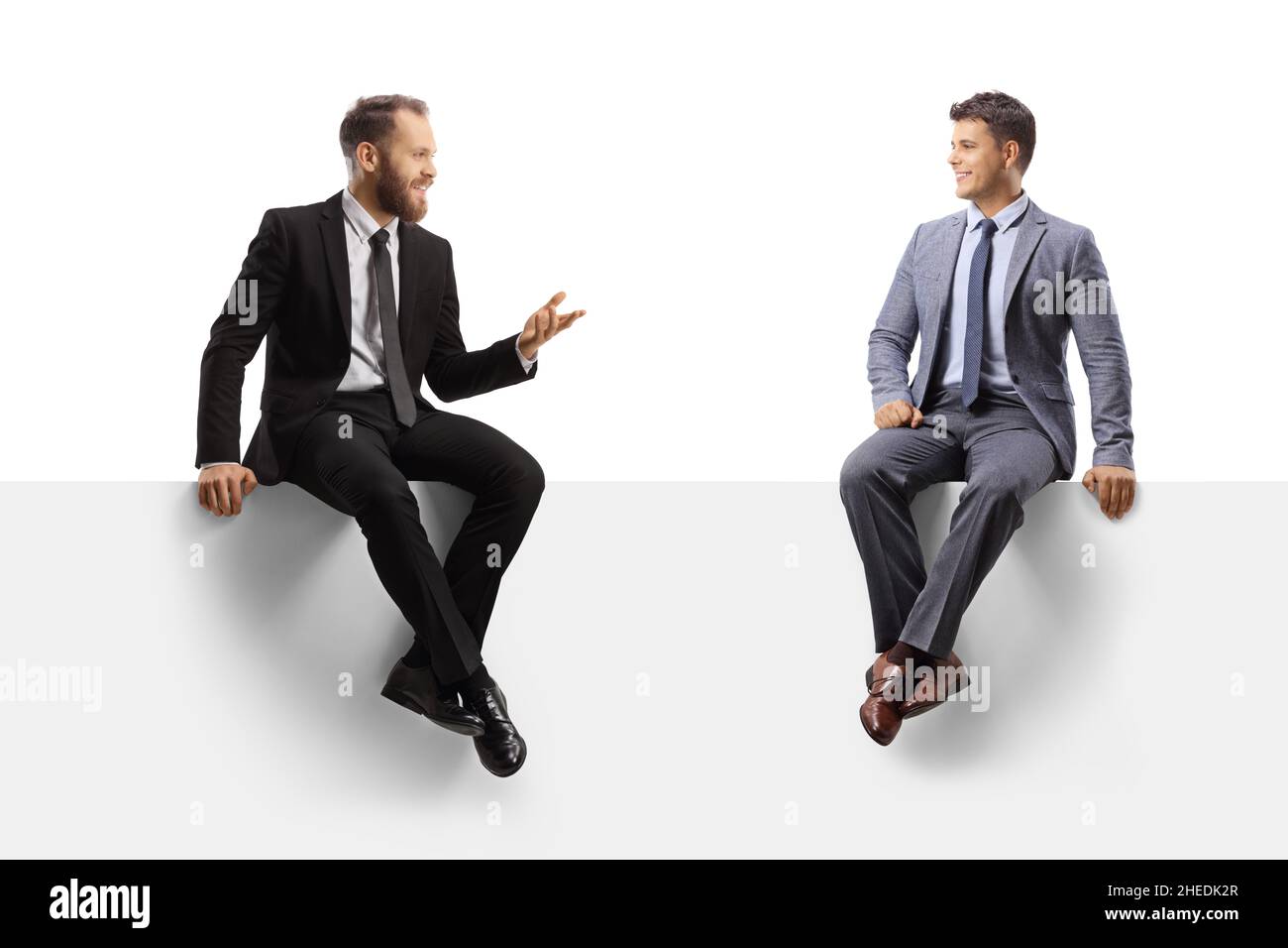 Two professional men sitting on a panel and talking isolated on white ...