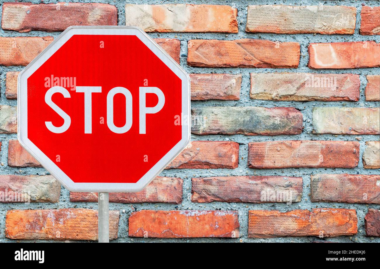 Red stop sign on a rod with Background of red brick wall Stock Photo ...