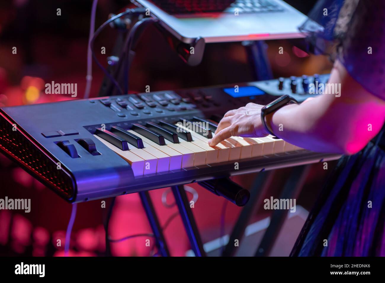 Close shooting of a keyboardist musician at work at a concert ...