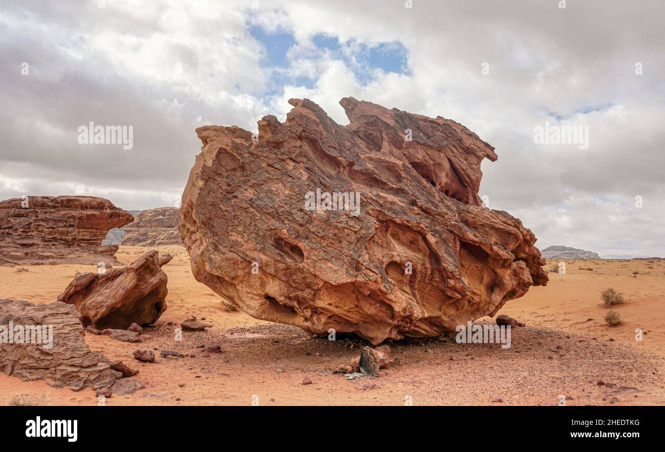 Large boulder, sides shaped by erosion on orange sand of Wadi Rum ...