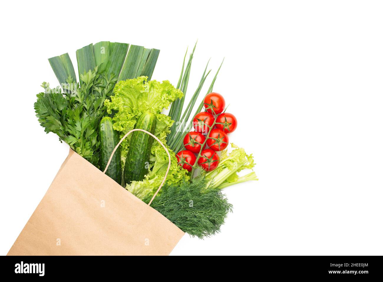 A set of vegetables and herbs in a paper bag isolated on white ...