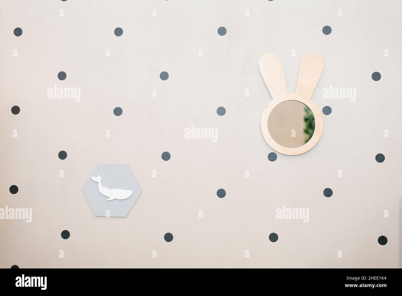 A mirror in the form of a rabbit made of wood hangs on the wall with ...