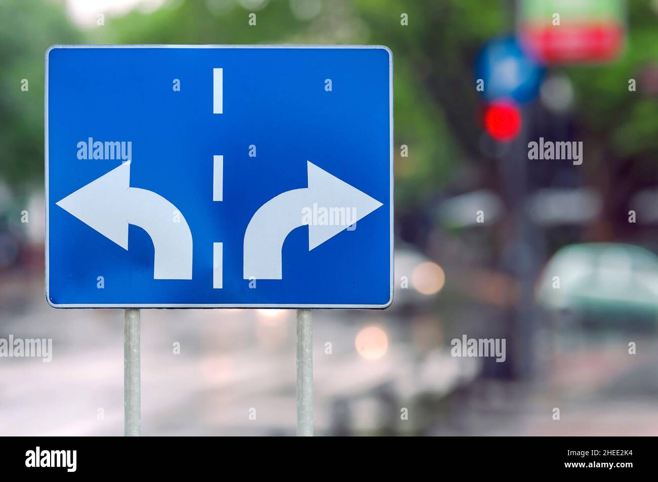 Road sign with opposite arrows on two rod Stock Photo - Alamy