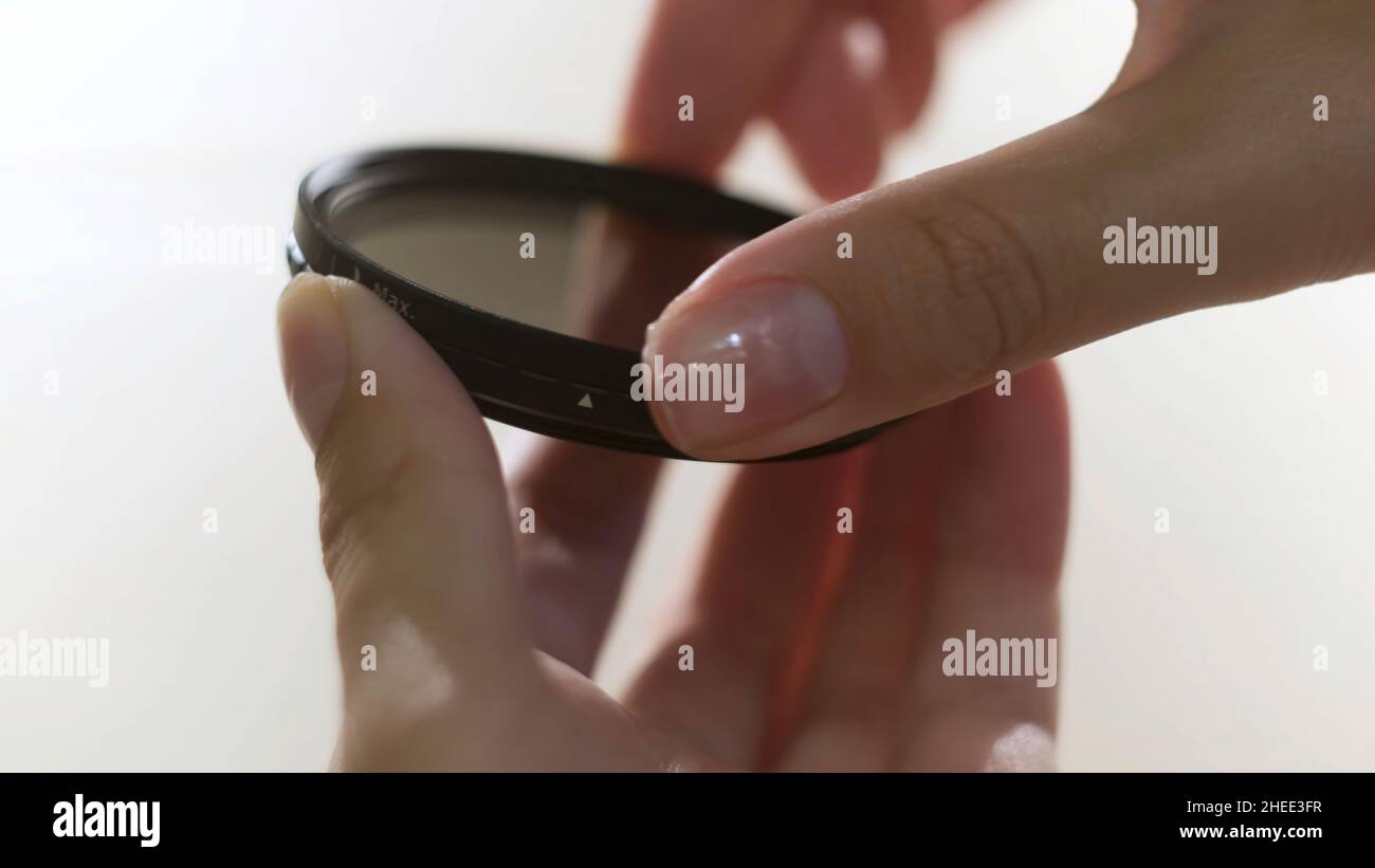 Close up of polarizing lens filter in girls hands isolated on white ...