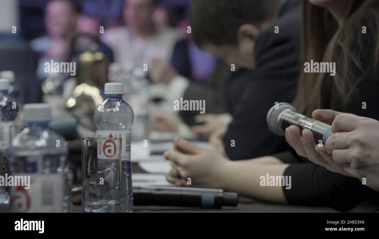 Group of business people sitting in a line at conference. Close-up of ...
