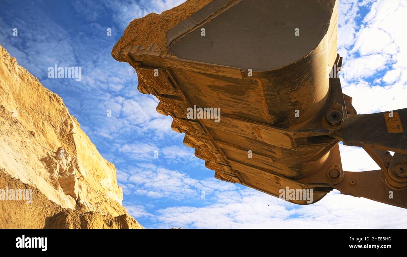 Excavator in action at the construction site. Bottom view of excavator ...